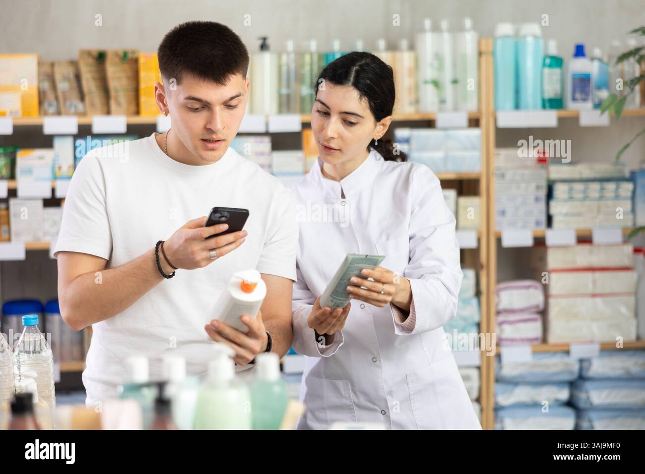 Man buyer scans cream qr code with woman pharmacist Stock Photo - Alamy