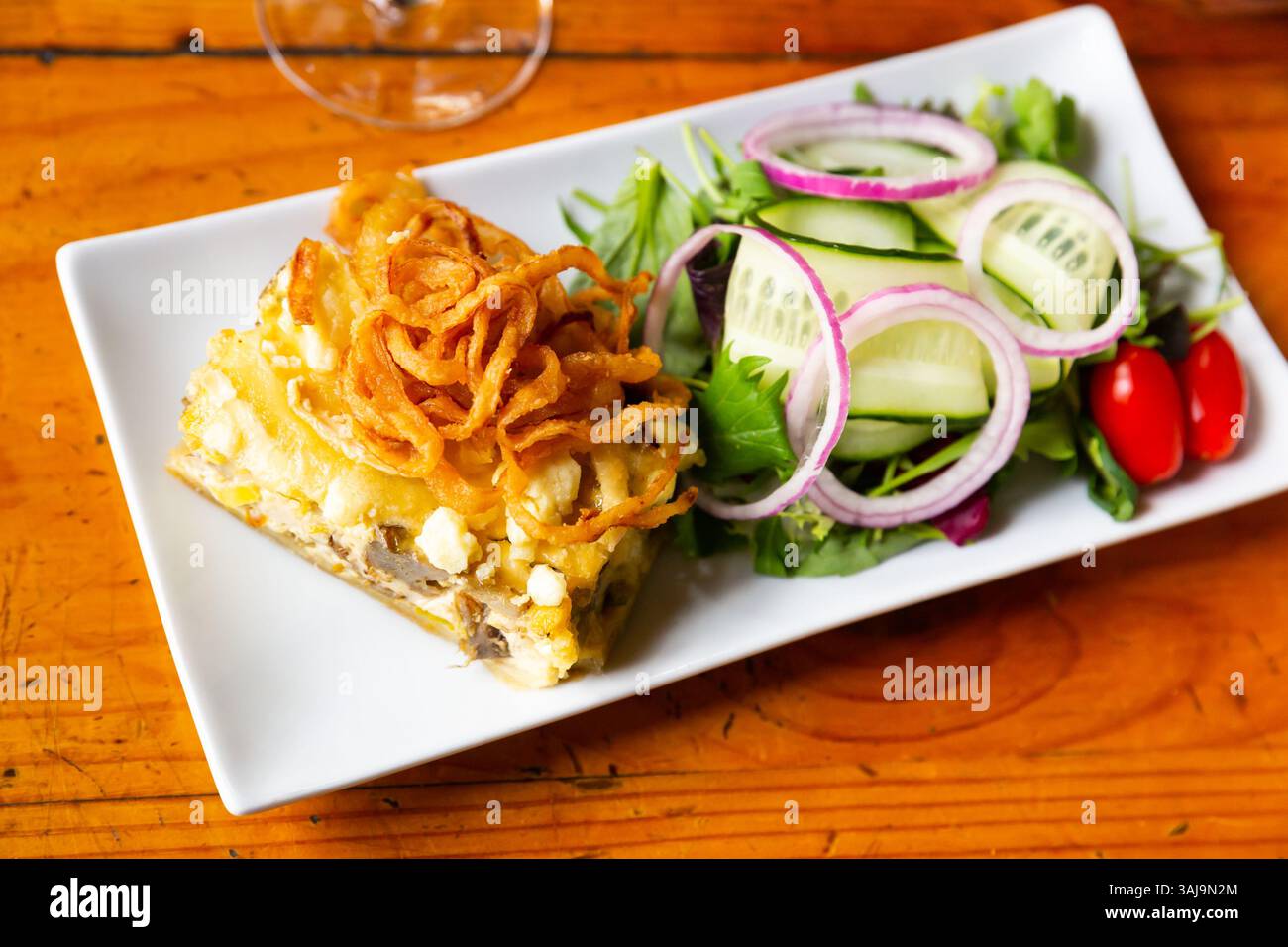 Quiche Lorraine slice with fried onions and vegetable salad Stock Photo ...