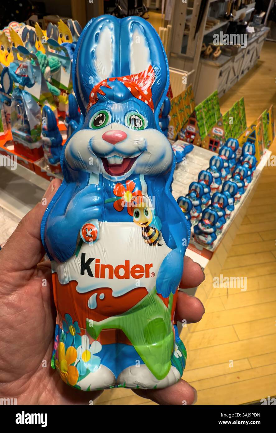 Customer holding a blue kinder surprise chocolate easter bunny in a ...