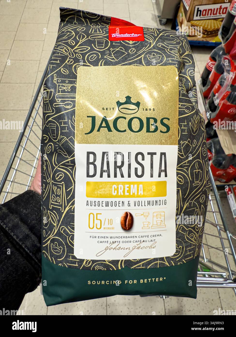 Shopper selecting a bag of jacobs barista crema coffee beans in a ...