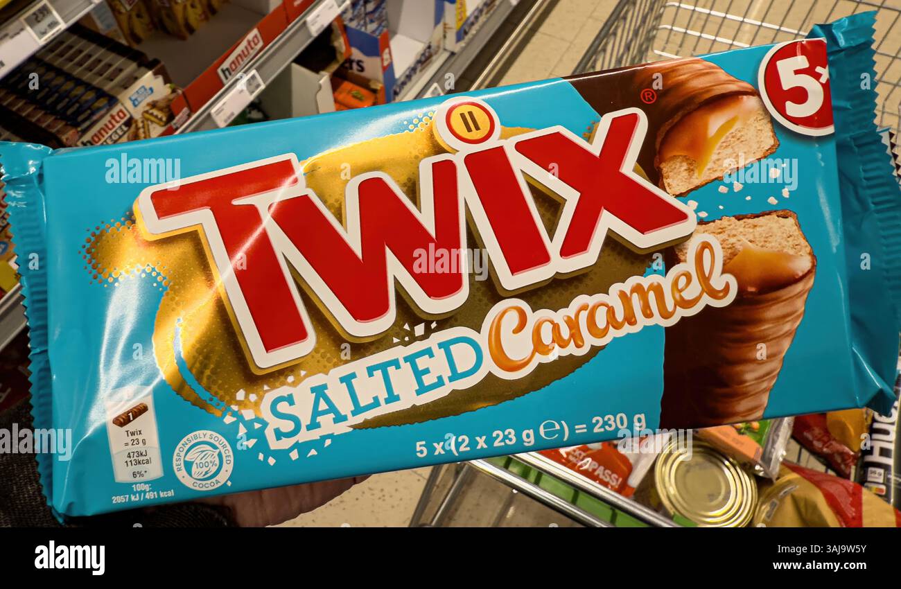 Pack of twix salted caramel chocolate bars held by a customer in a ...