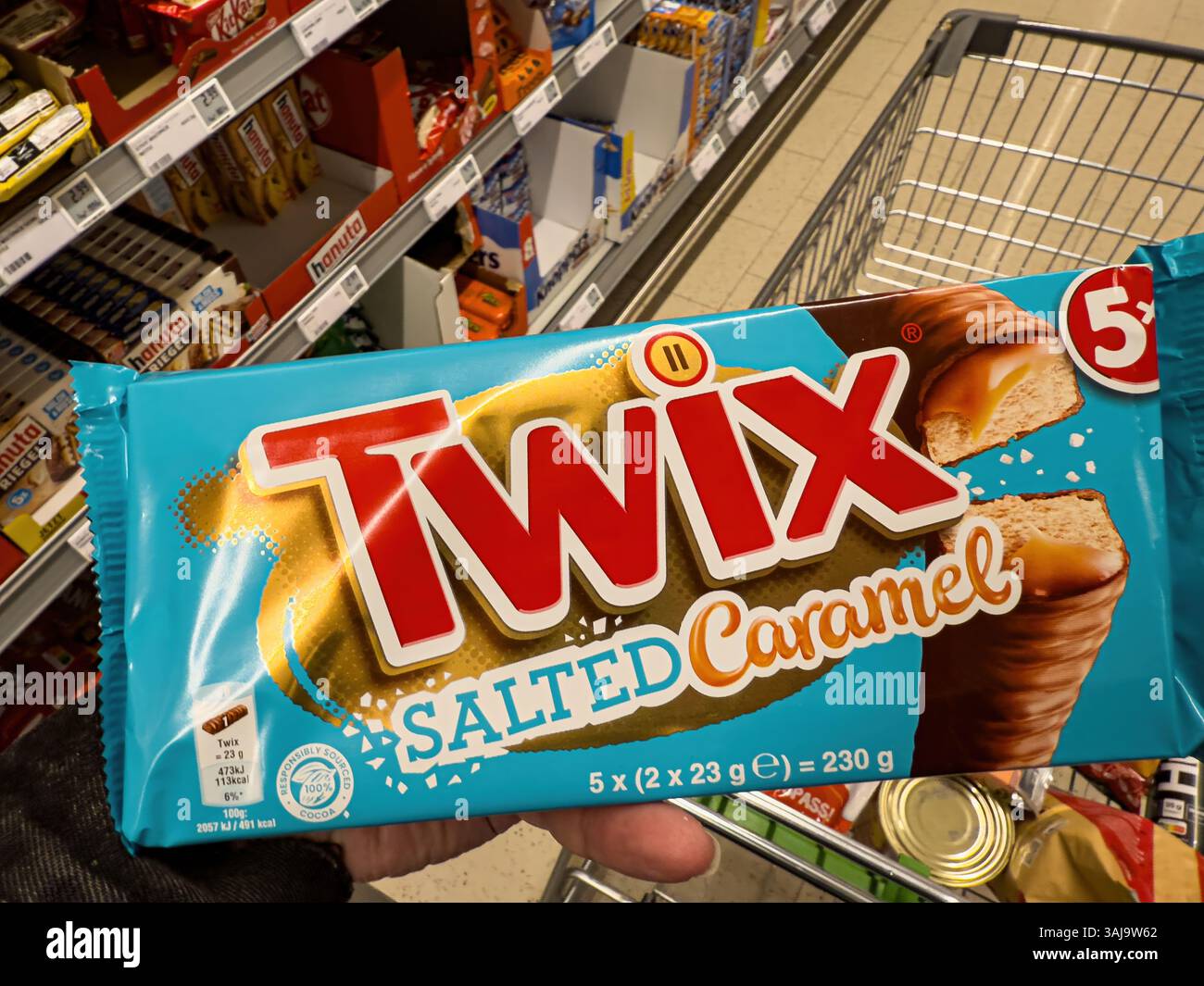 Customer is holding a package of twix salted caramel chocolate bar in a ...