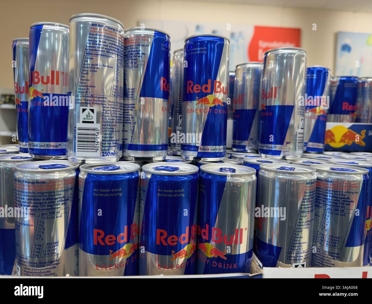 Multiple red bull energy drink cans are neatly arranged on a store ...