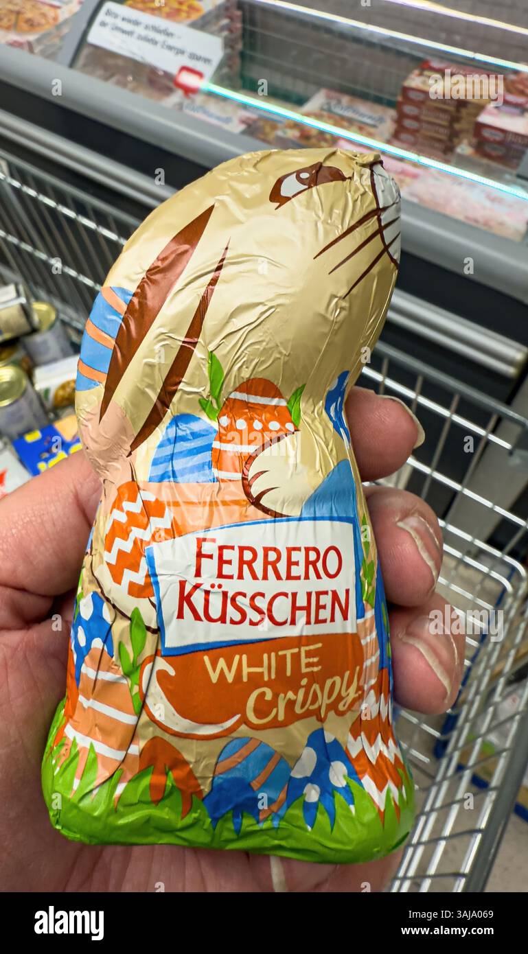 Hand holding a ferrero kusschen white crispy chocolate easter bunny in ...
