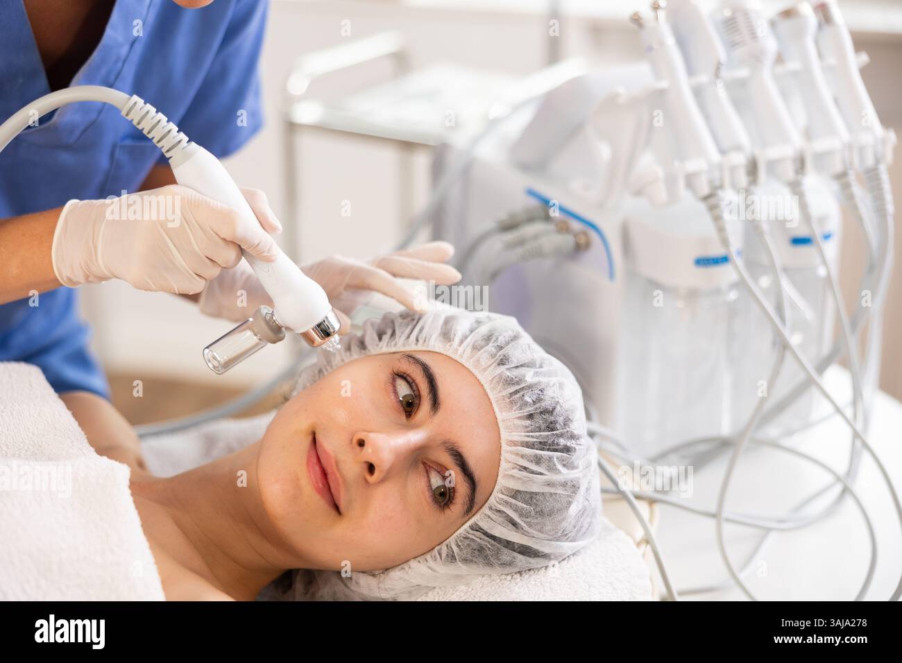Female patient undergoing facial skin ionization procedure using ion ...