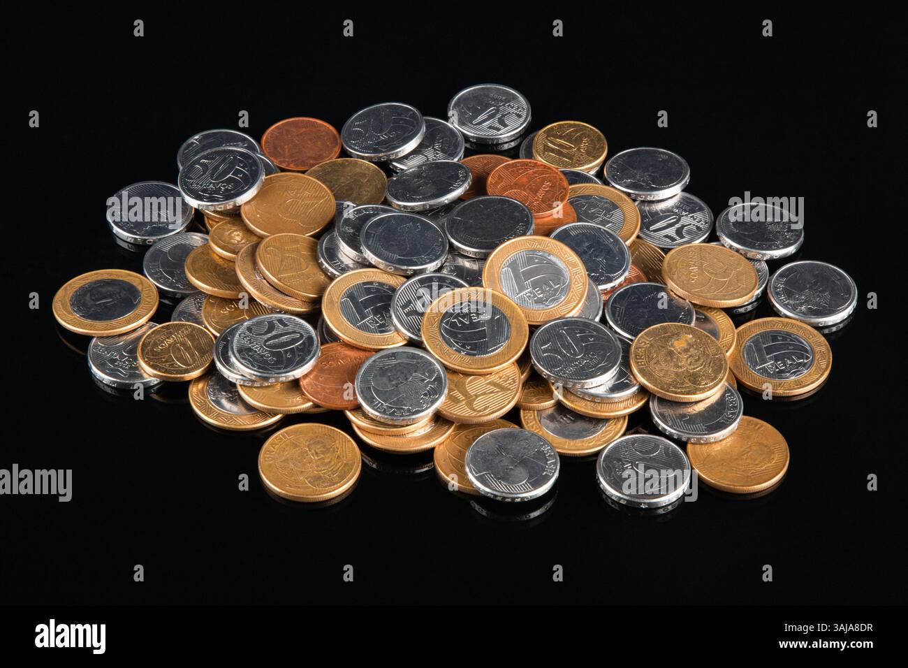 A pile of Brazilian Real coins on a black background Stock Photo - Alamy