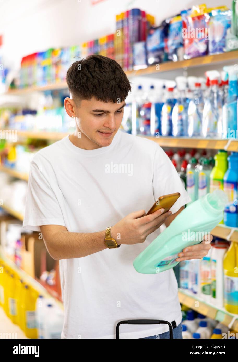 in supermarket, man scans qr code of detergent, typed on label Stock ...
