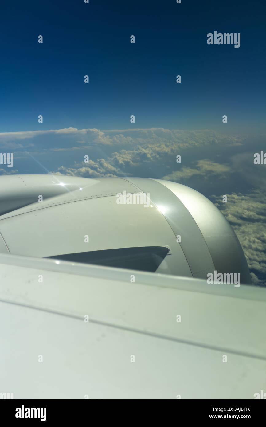 A close-up view captures an airplane wing with a jet engine, soaring ...