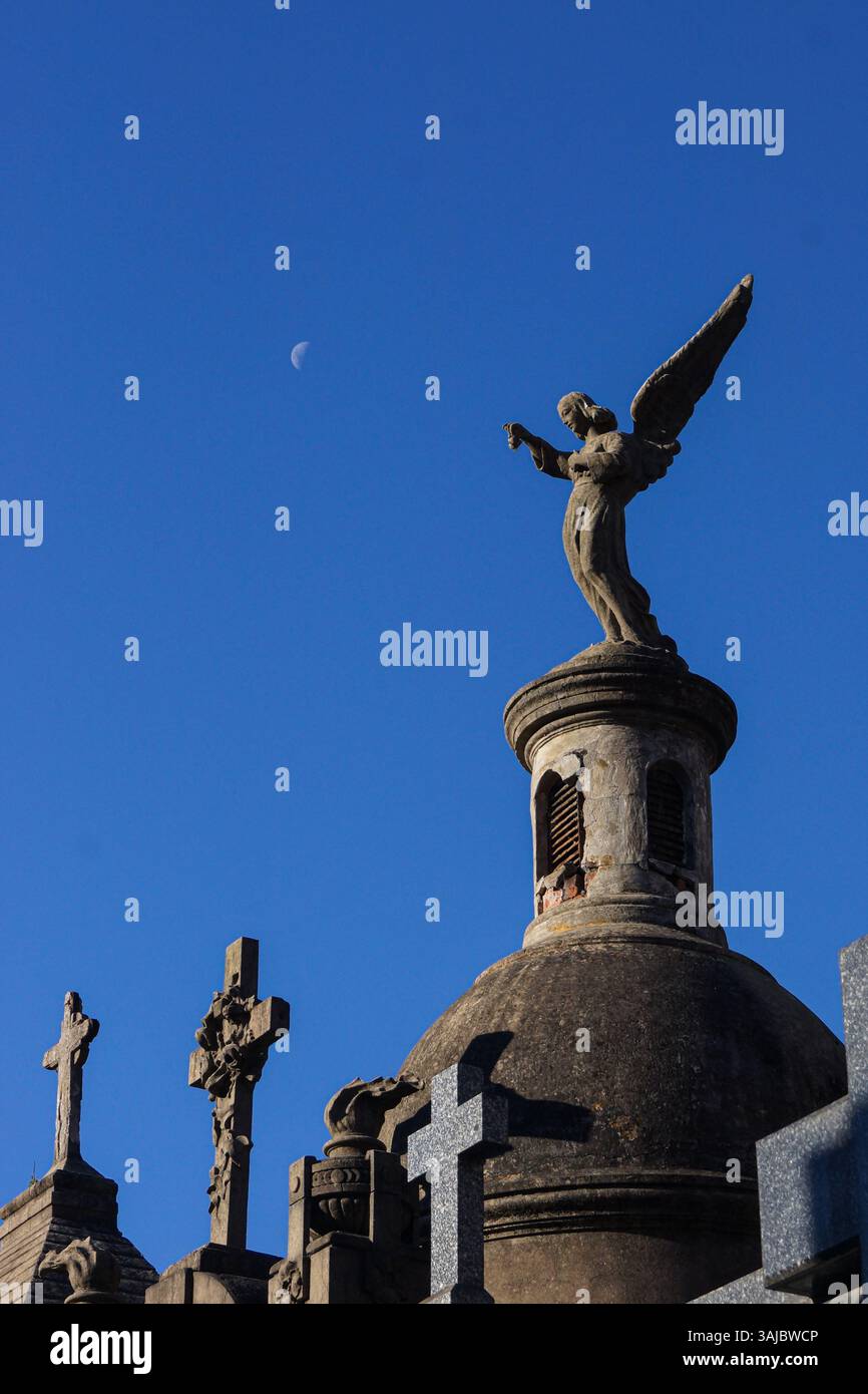 Angel pointing toward the moon from the dome of a mausoleum in Recoleta ...