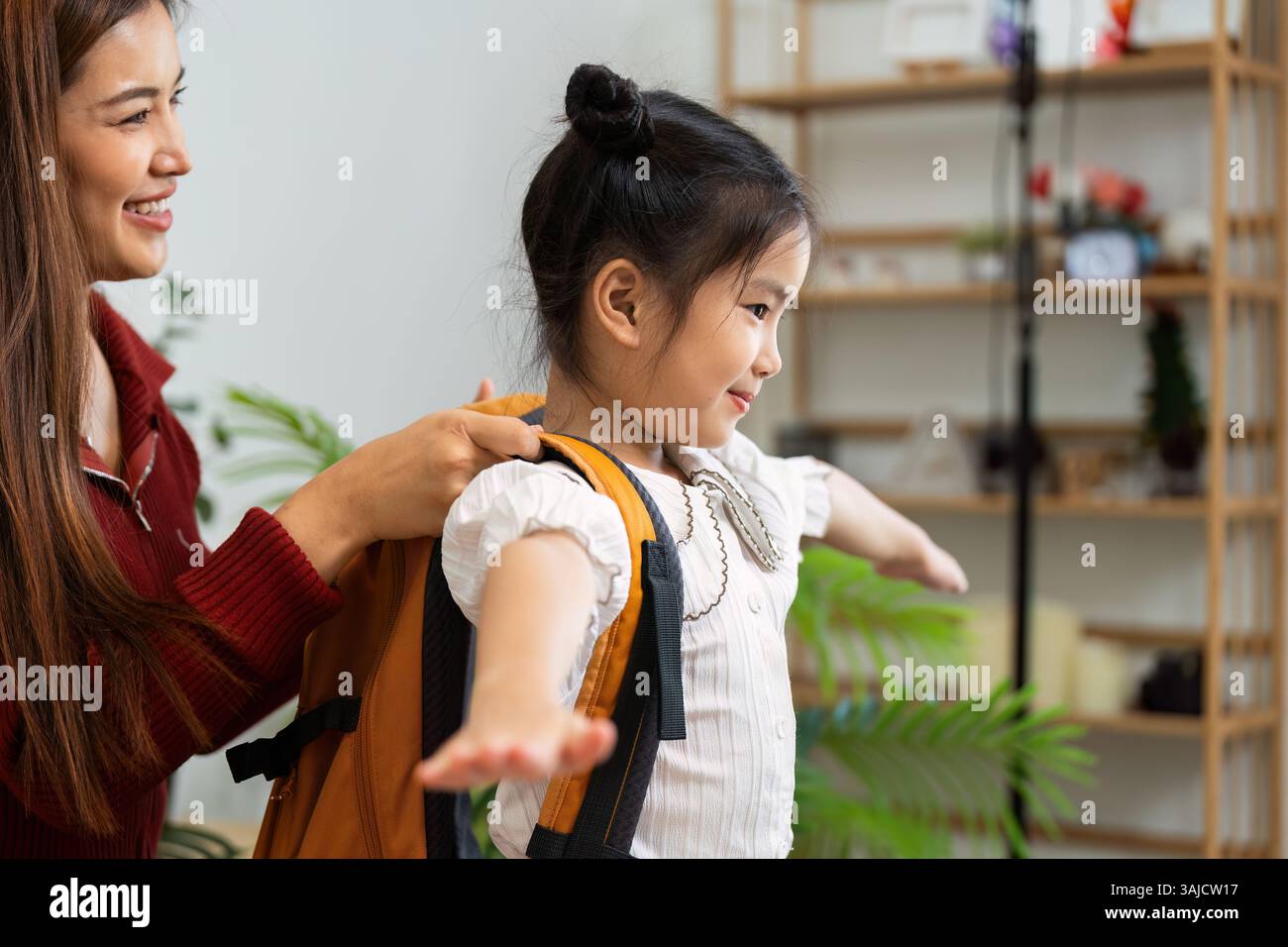 Getting Ready for School with a Backpack. A girl trying on her backpack ...