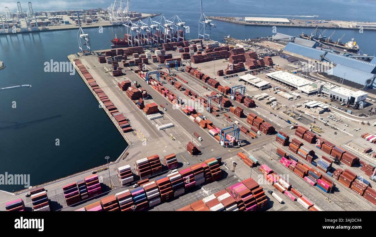 An aerial view of the Port of Long Beach reveals a vast, bustling trade hub with sprawling docks ...