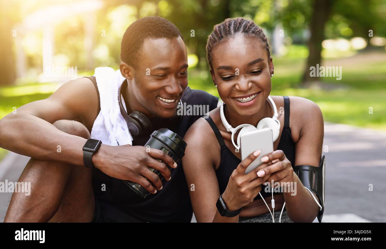 Fit Black Couple Using Smartphone After Training Outdoors, Checking ...