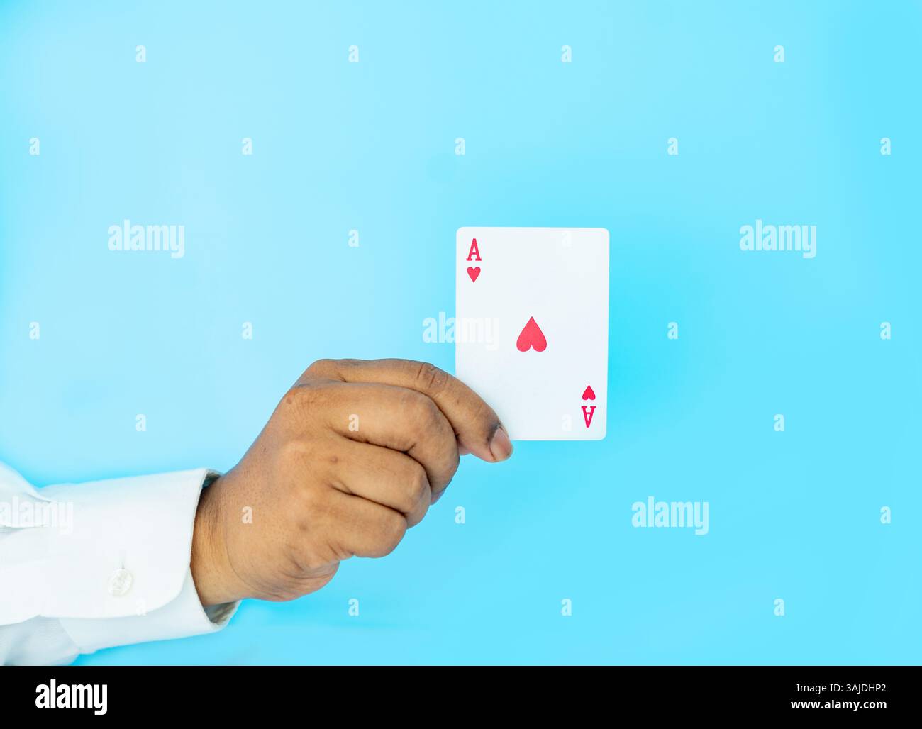 Close up hand shown a red Ace playing card on aqua background, concept ...