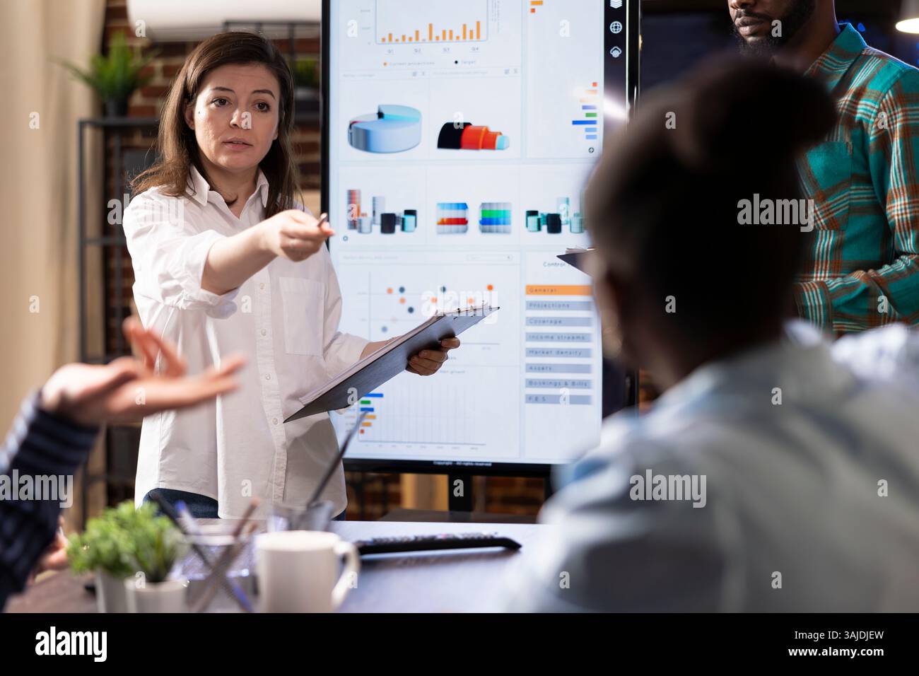 Focused businesswoman presents startup strategies, engaging diverse group in company research ...