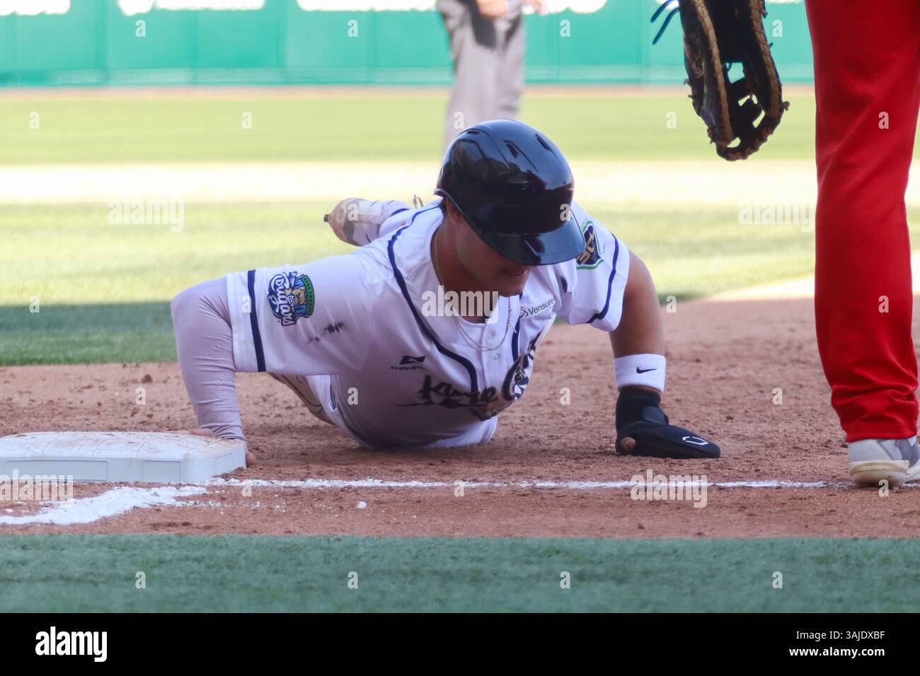 Brantley Bell #3 of Kane County Cougars slides to the first base plate ...
