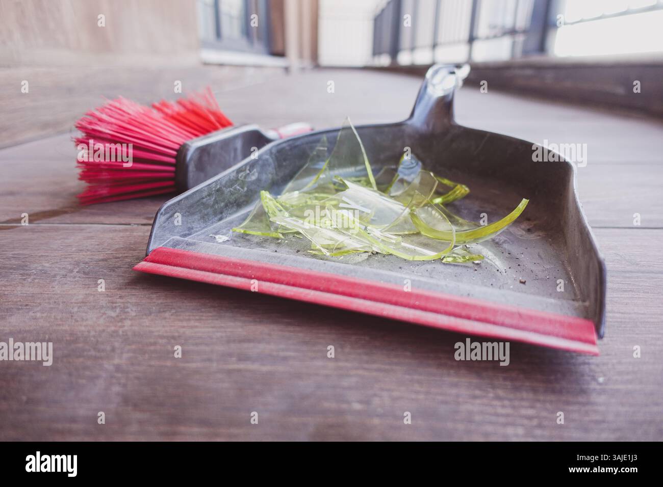 Cleaning up broken glass during afternoon chores at home Stock Photo ...