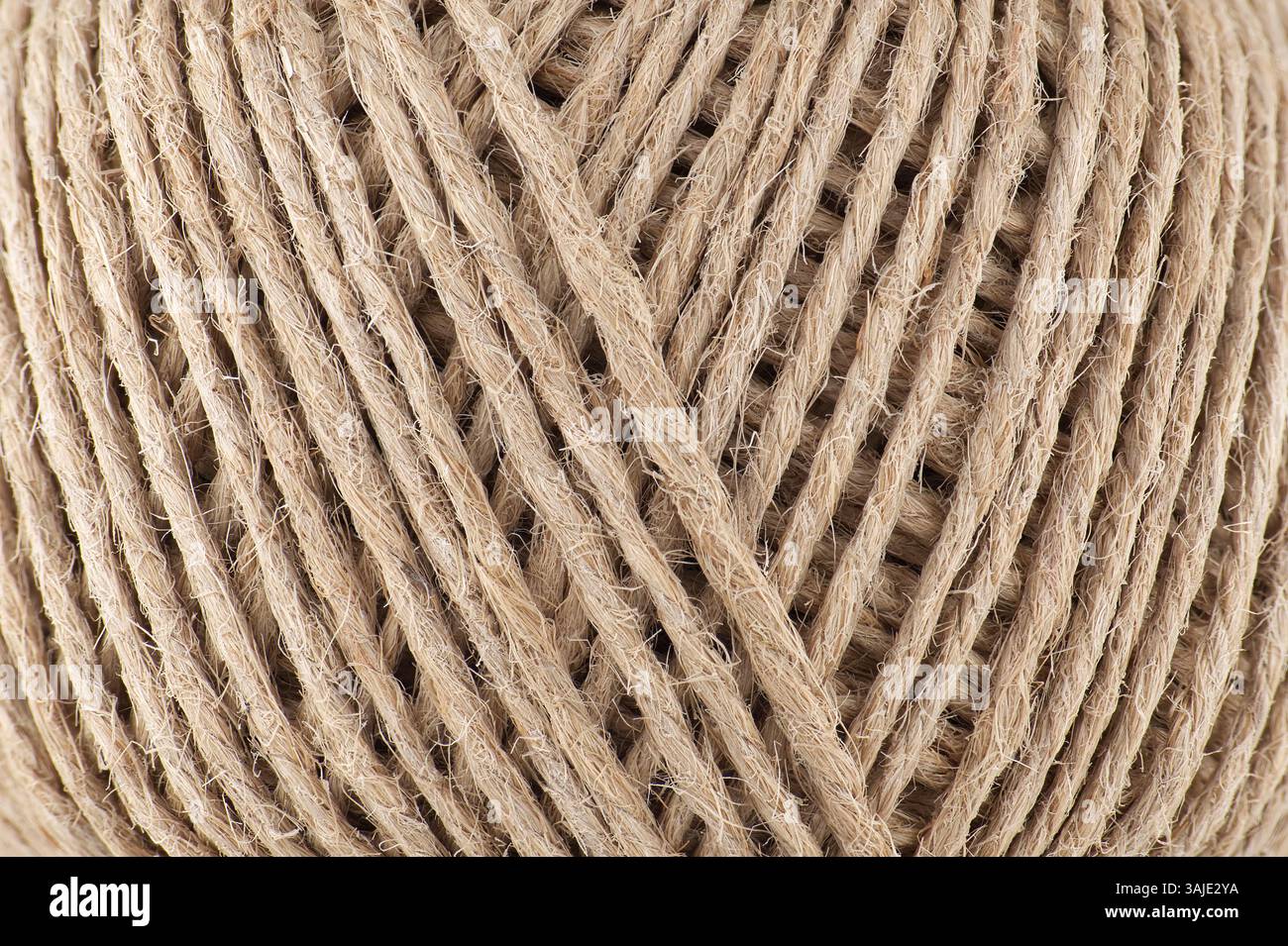 A tightly wound ball of natural twine, showing the textured details and ...
