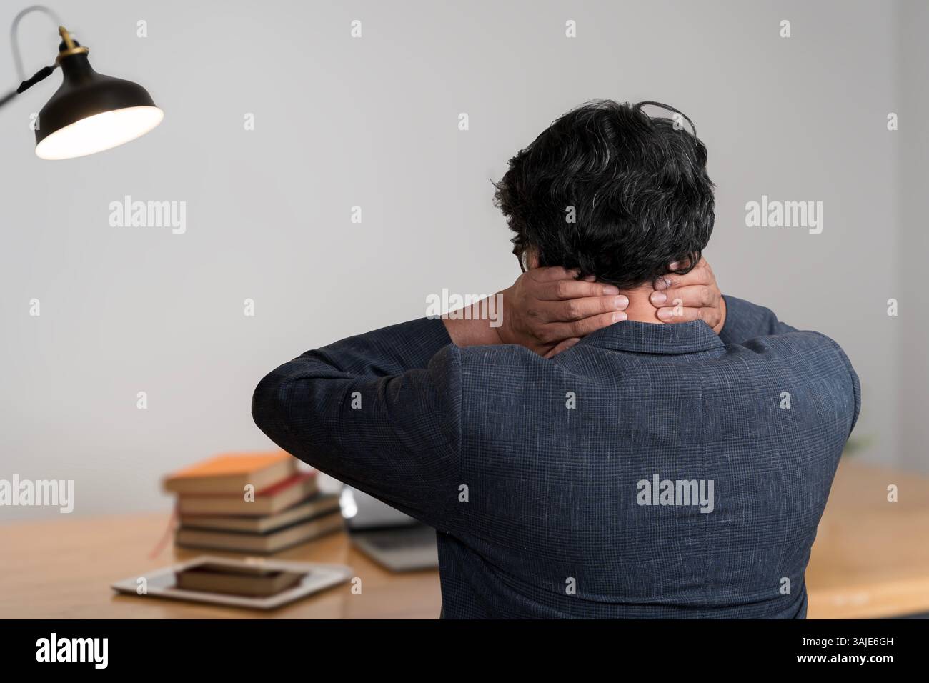 Neck ache concept. Young man sitting at office desk feeling hurt having ...