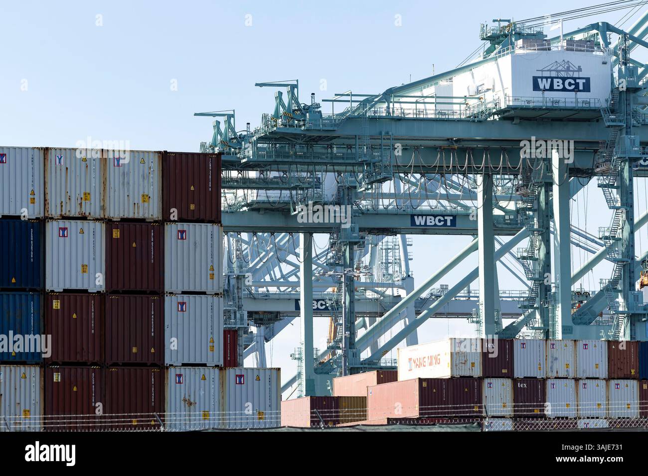 Ship-to-shore cranes (STS) with stacks of shipping containers at the ...