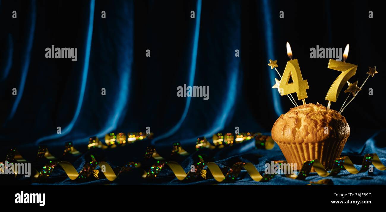 Number 47 gold celebration candle and small stars in sweet cupcake on ...