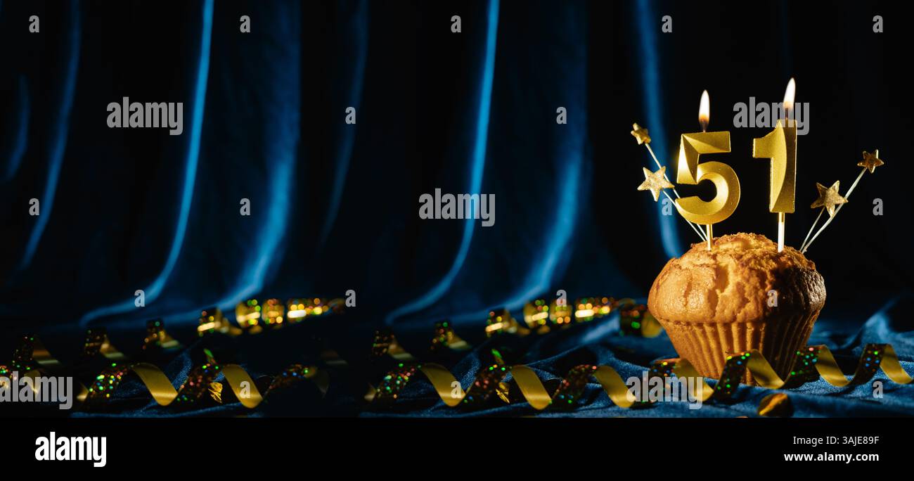 Number 51 gold celebration candle and small stars in sweet cupcake on ...