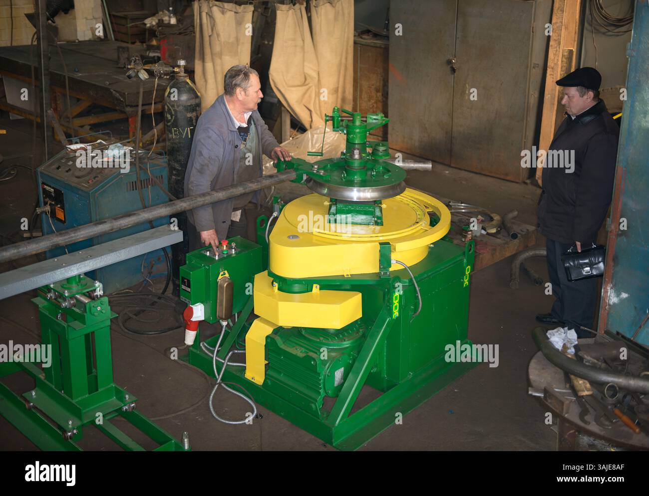 The boss with the worker tests new machine for pipe bending at the ...