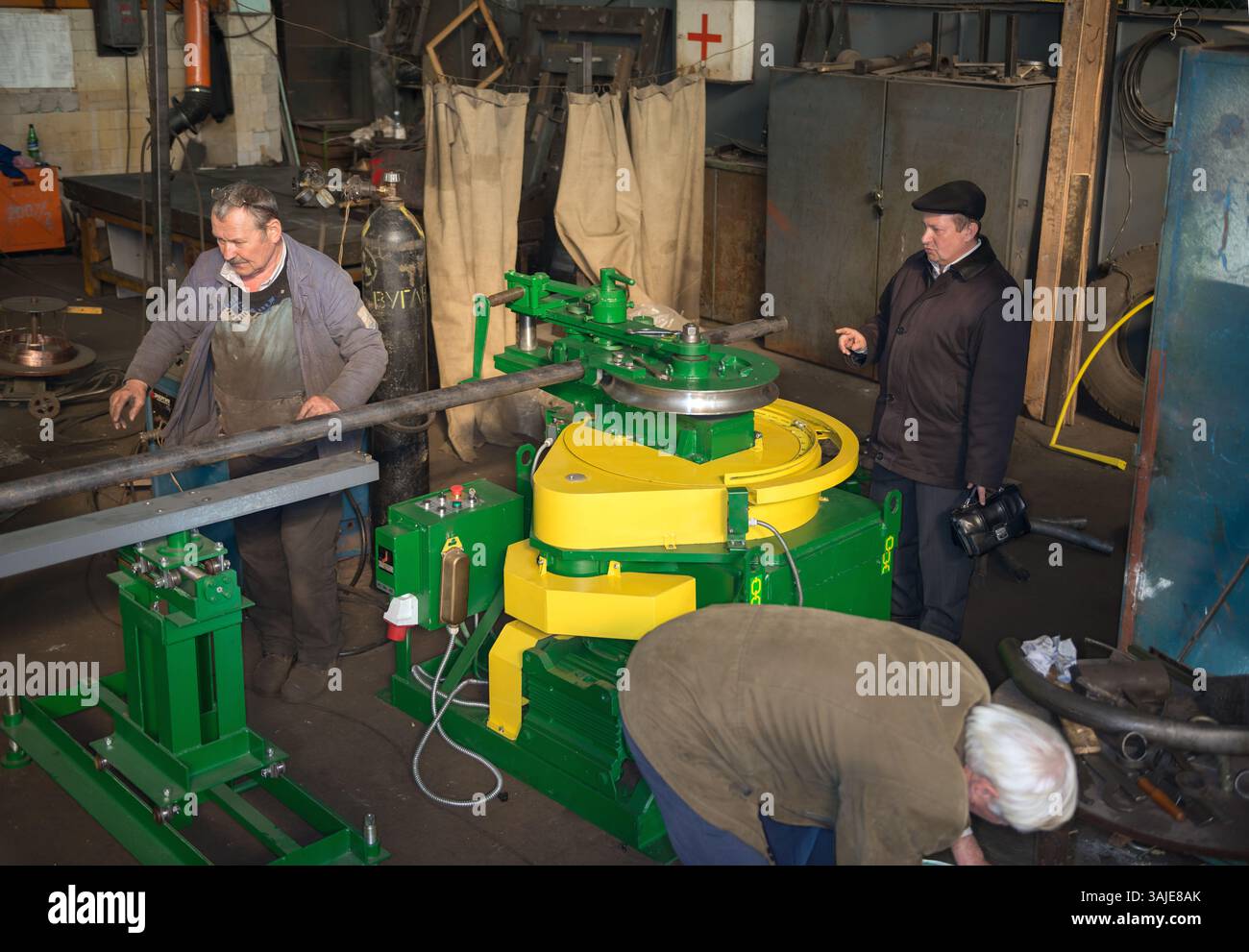 The boss with the worker tests new machine for pipe bending at the ...