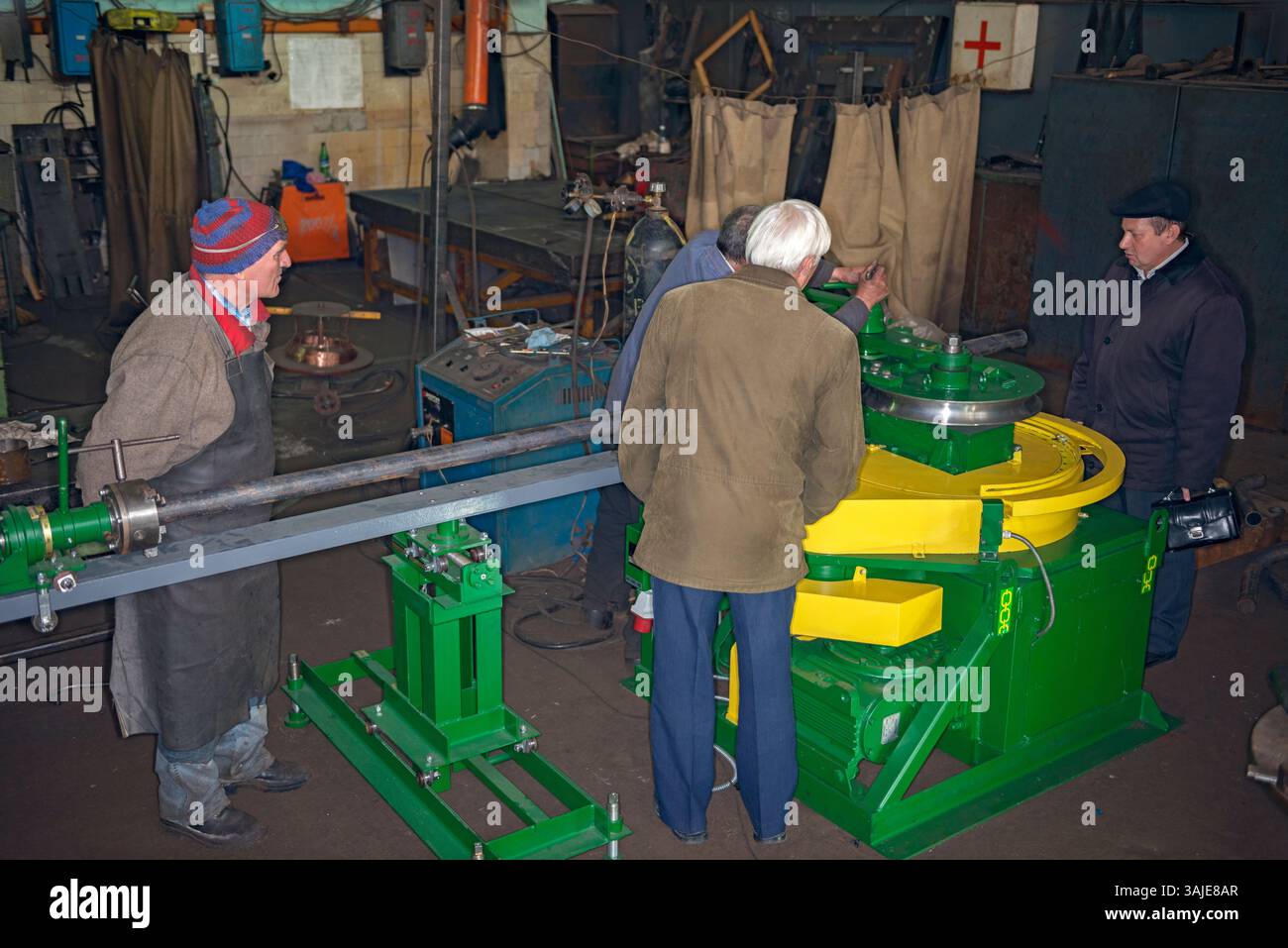 The boss with the workers and designer tests new machine for pipe ...