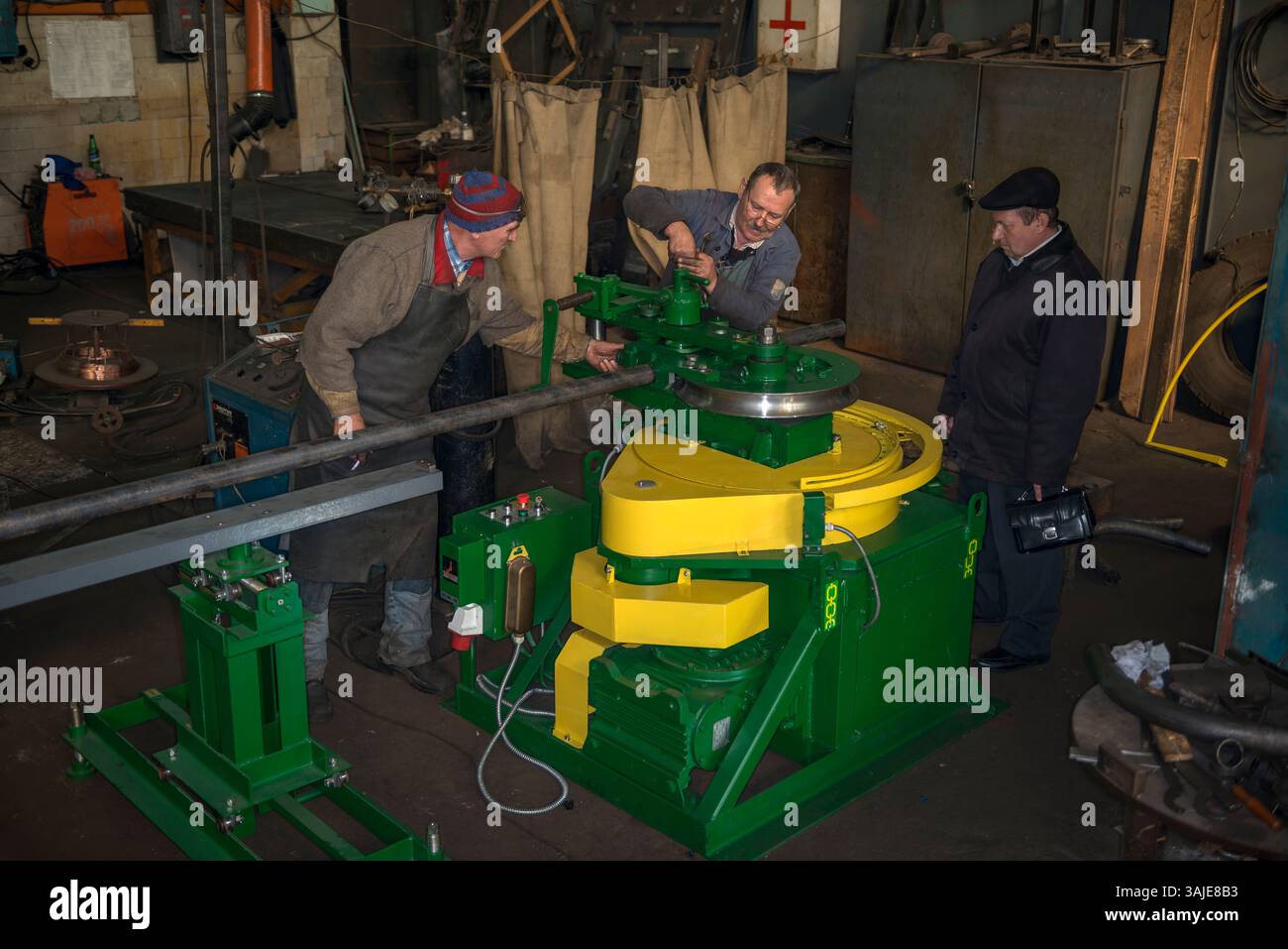 The boss with the workers tests new machine for pipe bending at the ...