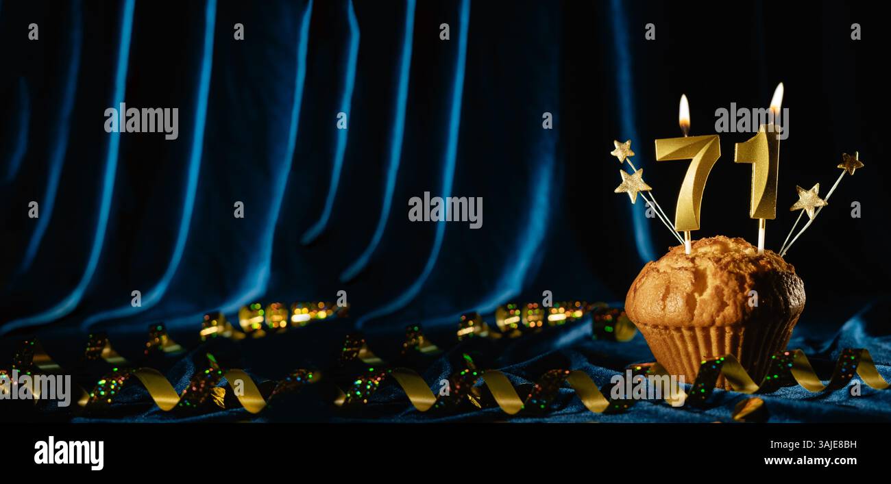 Number 71 gold celebration candle and small stars in sweet cupcake on ...