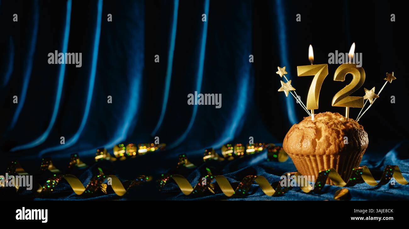 Number 72 gold celebration candle and small stars in sweet cupcake on ...