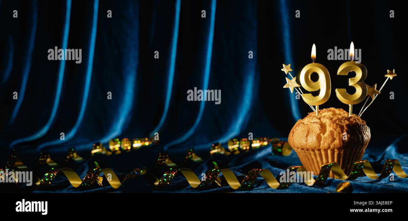 Number 93 gold celebration candle and small stars in sweet cupcake on ...