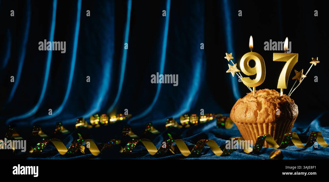 Number 97 gold celebration candle and small stars in sweet cupcake on ...