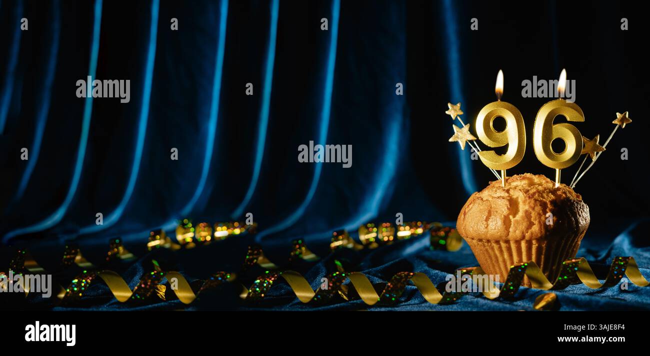 Number 96 gold celebration candle and small stars in sweet cupcake on ...