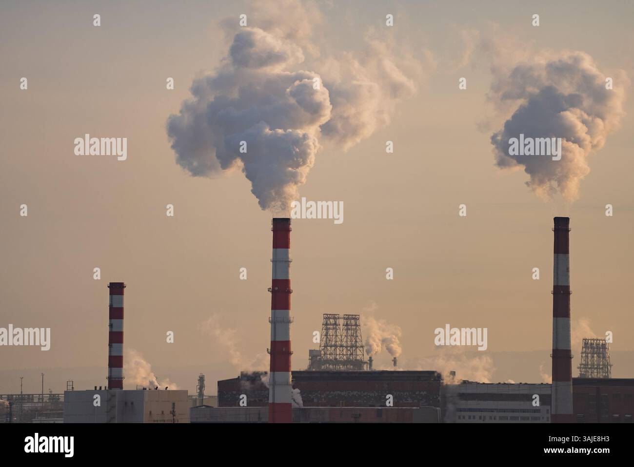 Large industrial chimneys releasing white smoke or steam into the ...