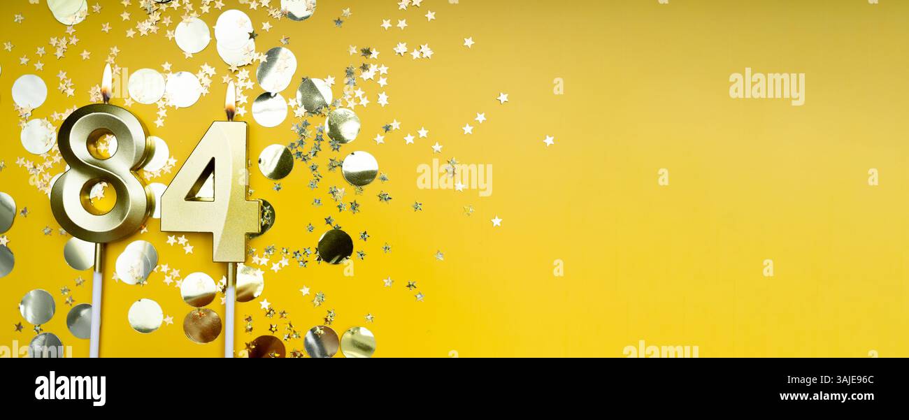 Eighty-four years birthday. Number 84 golden celebration candle. Yellow ...