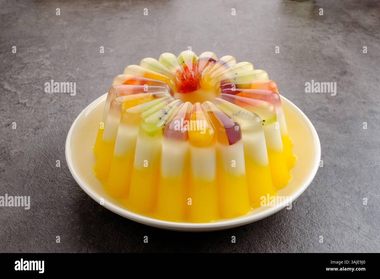 Delicious Mango Milk Pudding with fruit topping. Served on white plate ...