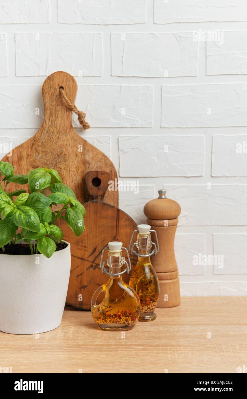 Kitchen counter with fresh basil plant, olive oil bottles, pepper mill ...