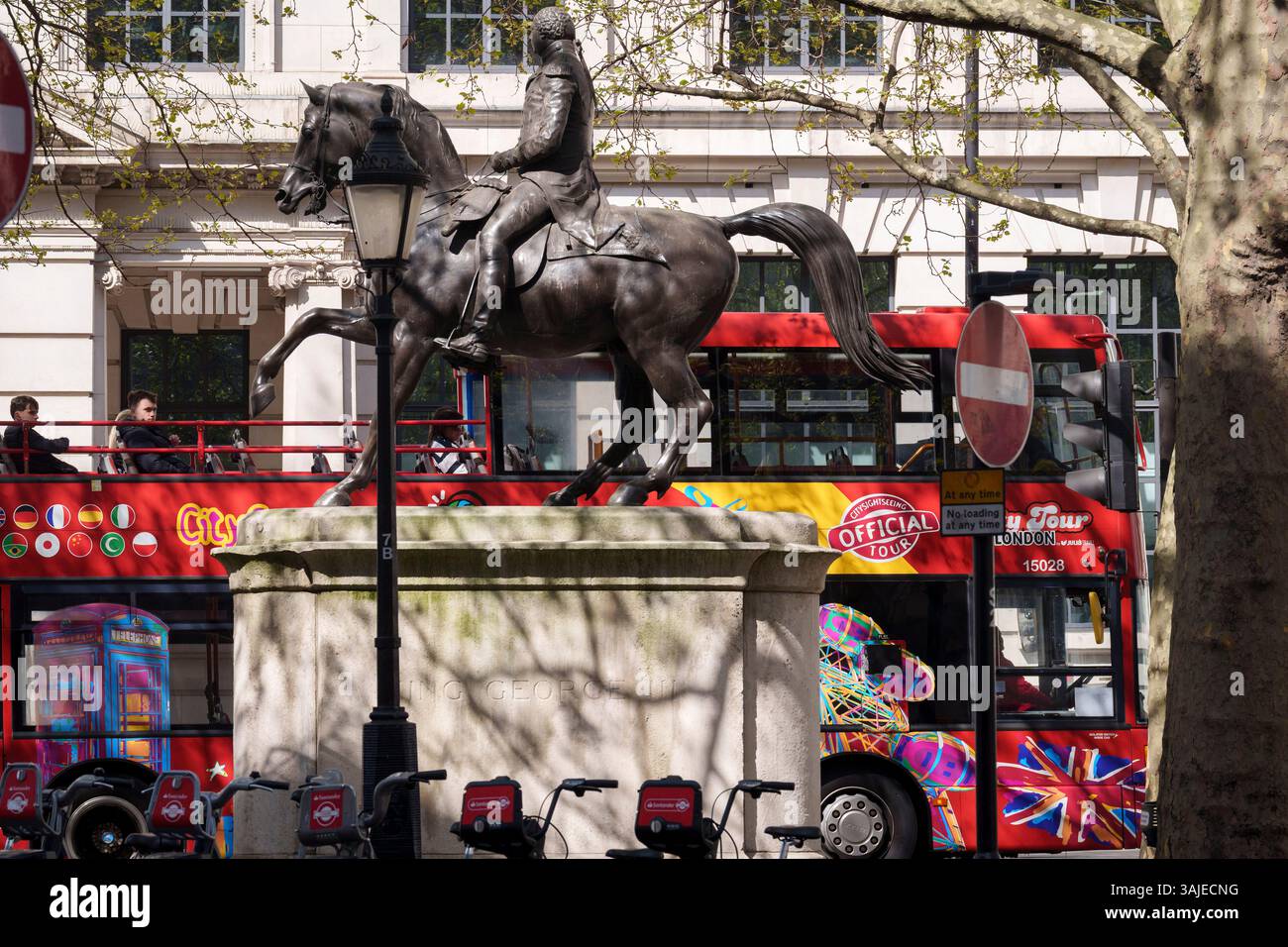 A tour bus passes the statue to King George III at the junction of Pall ...