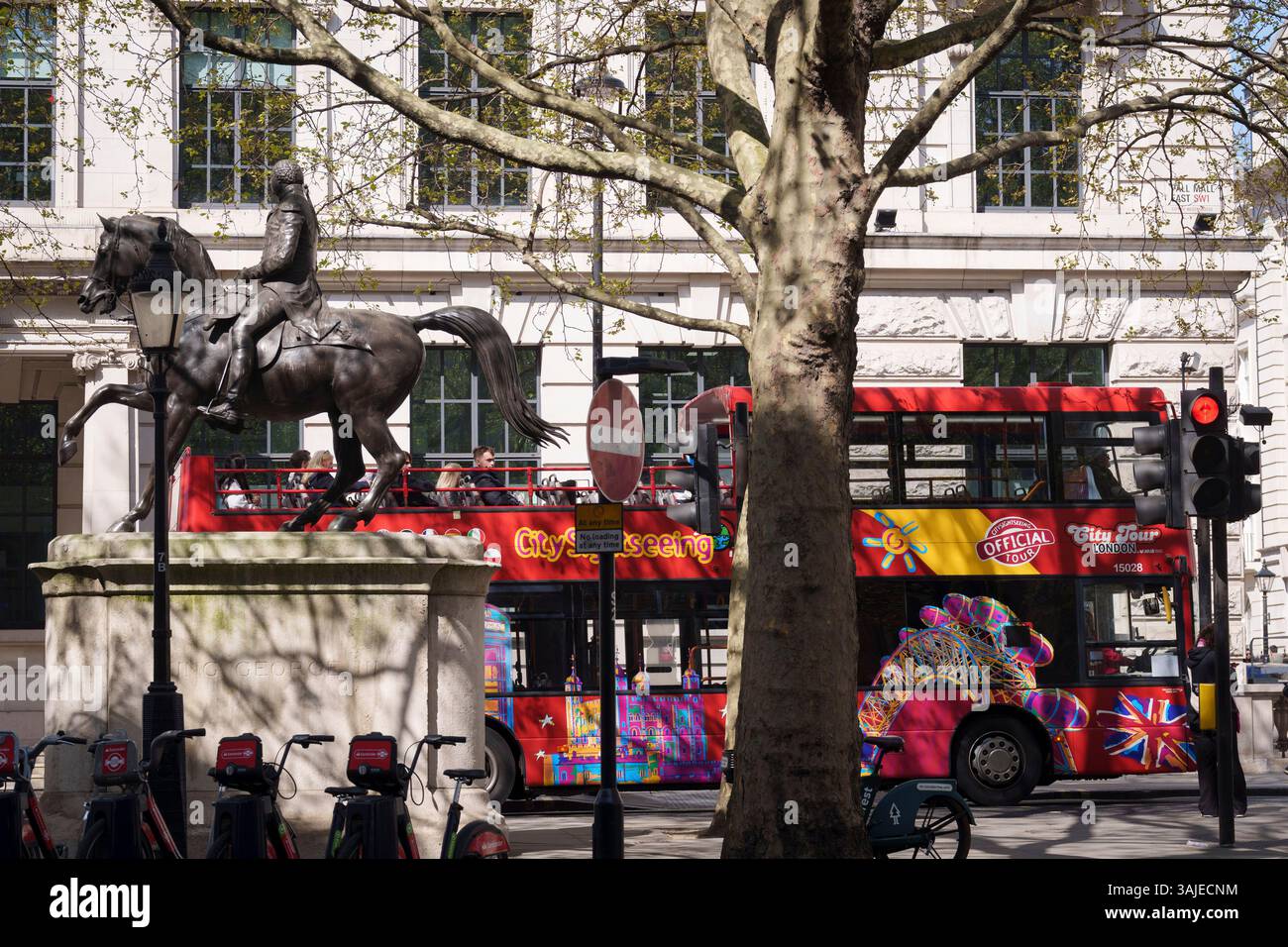 A tour bus passes the statue to King George III at the junction of Pall ...