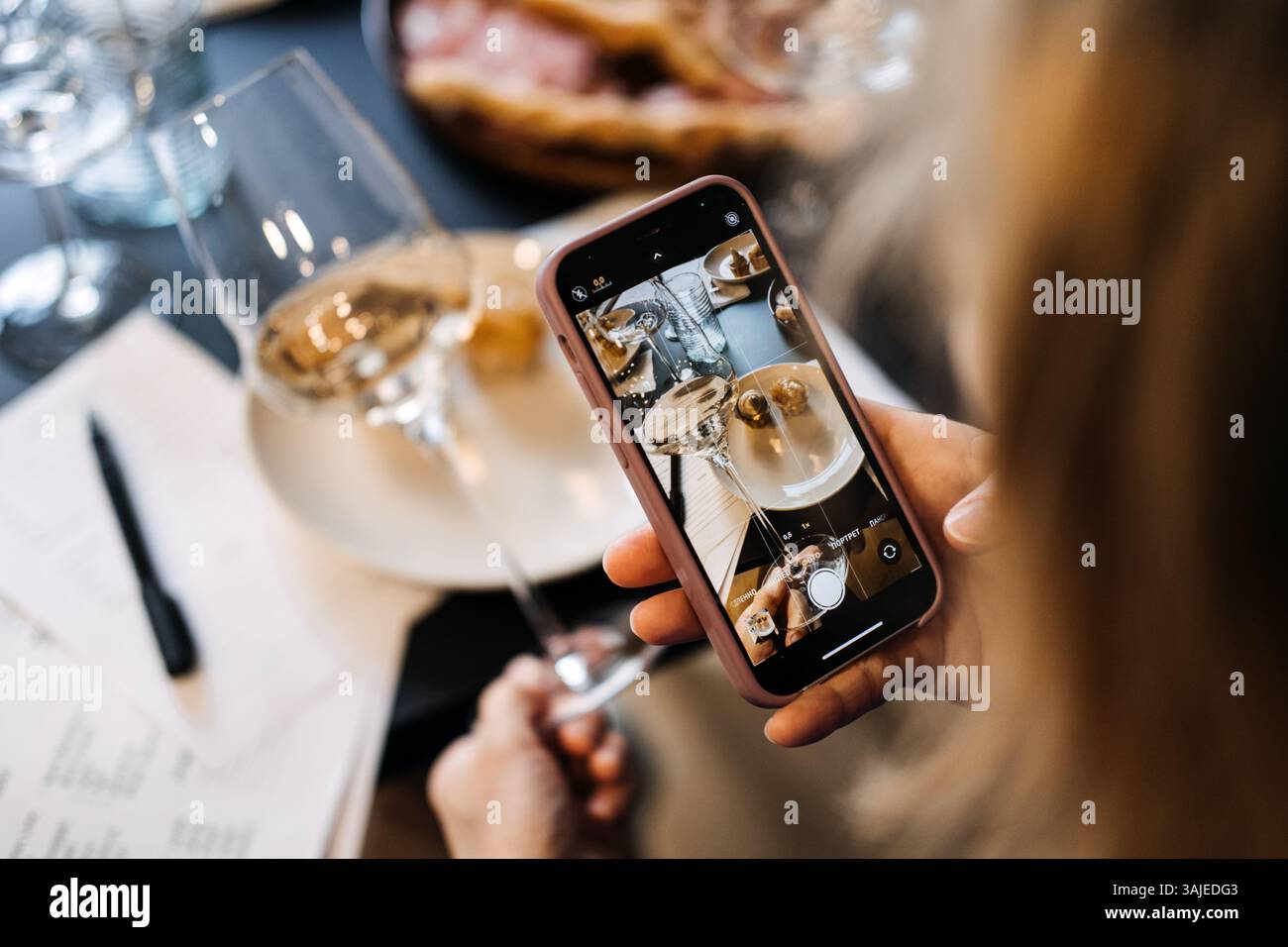 Person taking a photo of white wine during a food and wine tasting ...