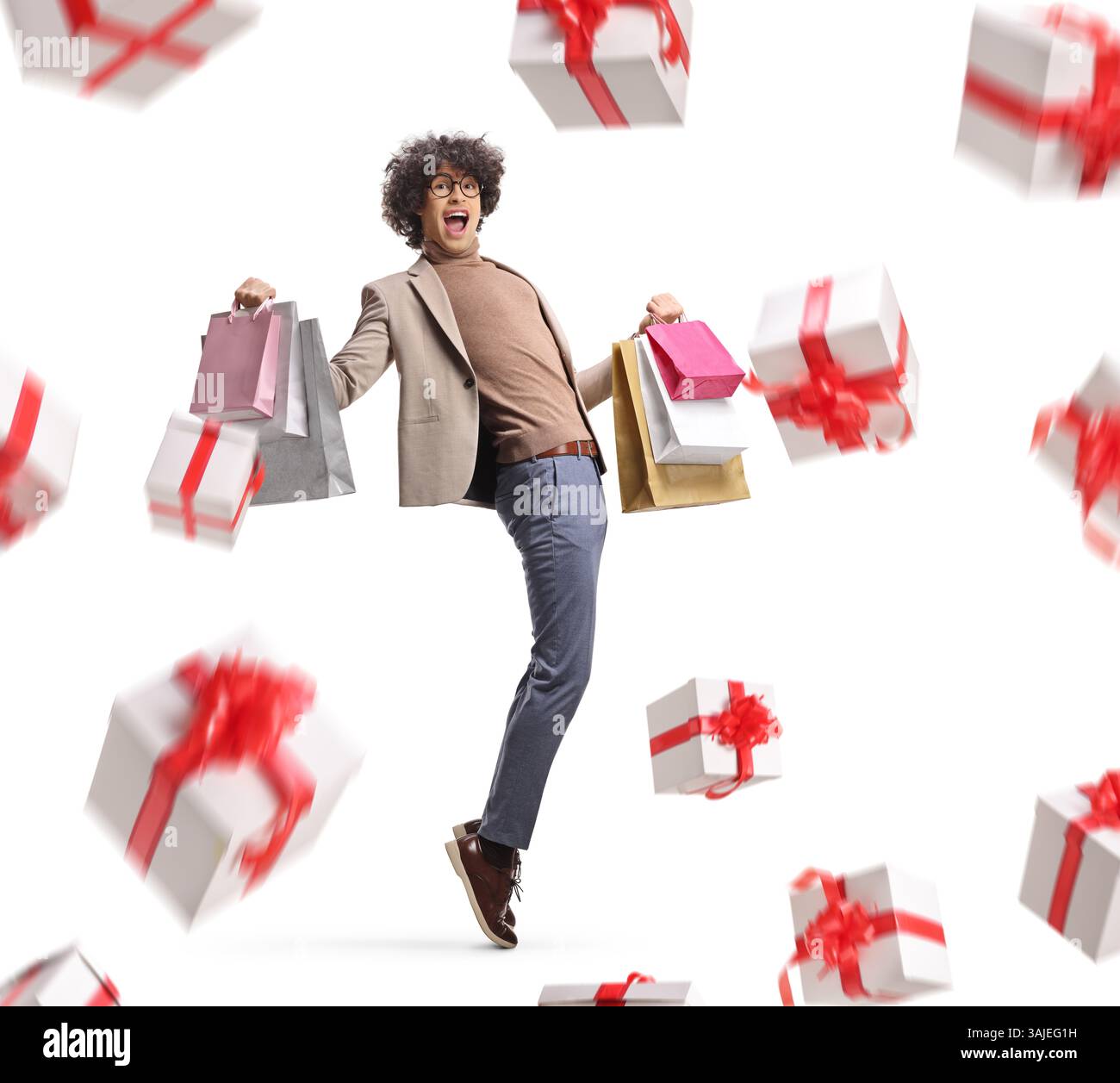 Excited young man holding shopping bags and dancing under falling ...