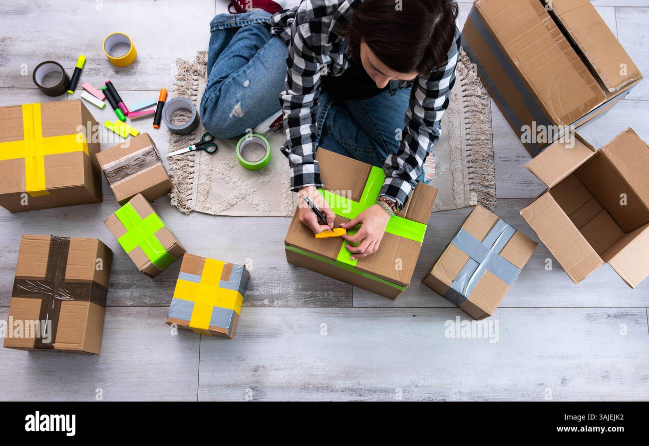Girl Packs Cardboard Boxes And Seals Them With Tape At Home As She ...