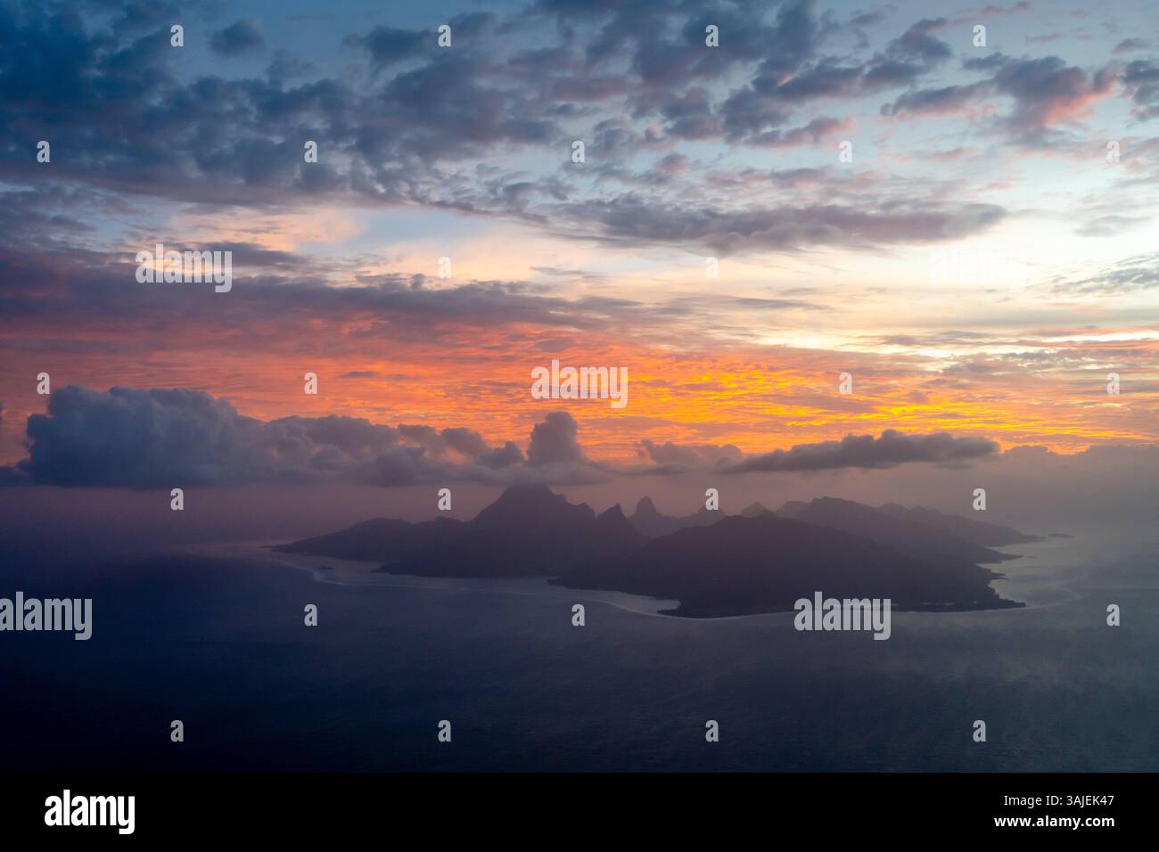 Moorea island, seen from above during sunset, reveals its rugged peaks ...