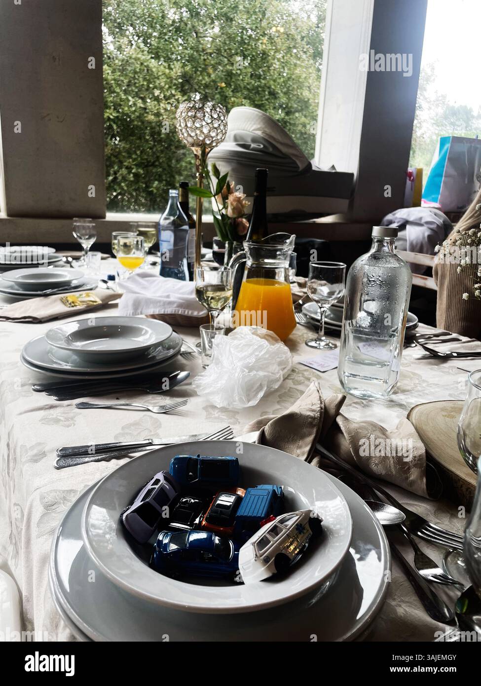 Elegant table setting featuring toy cars in a bowl under natural ...