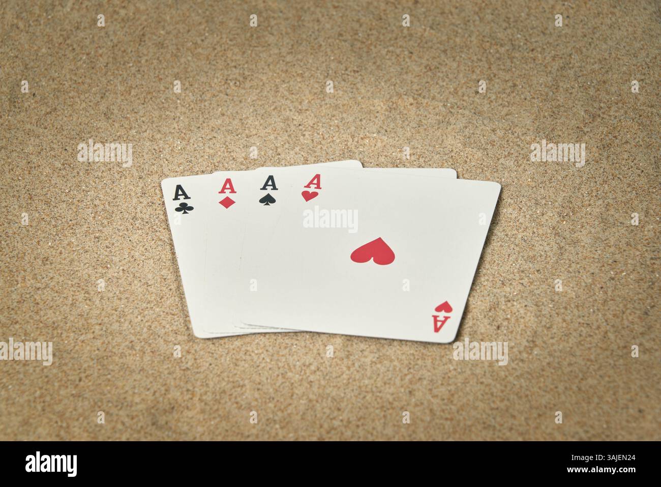 Four aces from the poker deck on beach sand and perfect for backgrounds ...