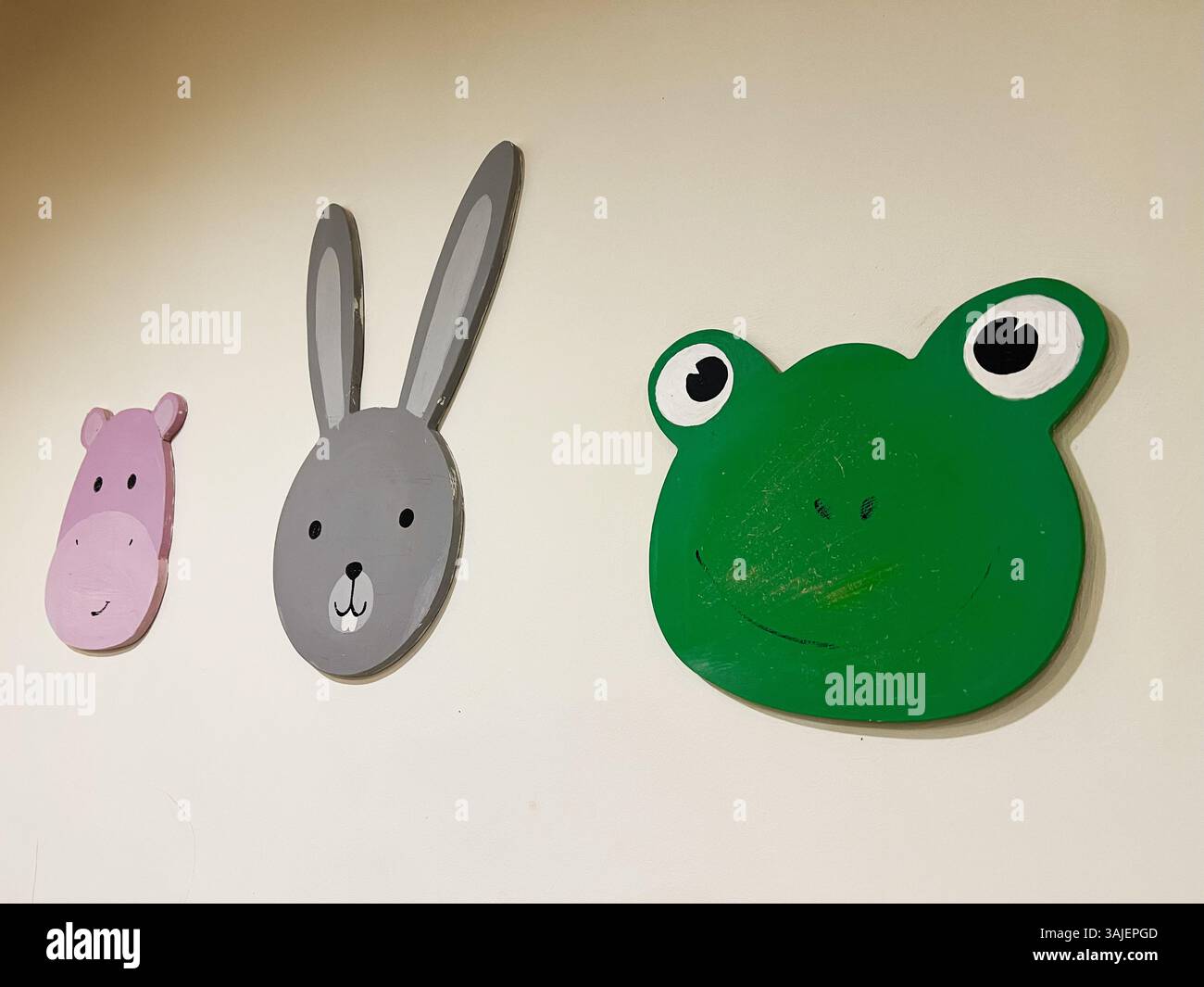 Decorative wall-mounted animal faces of a frog, rabbit, and hippo in ...