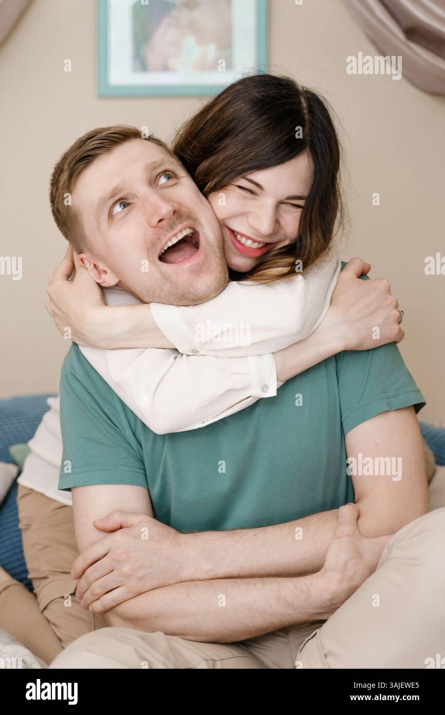 Happy pregnant woman and man hugging and laughing Stock Photo - Alamy