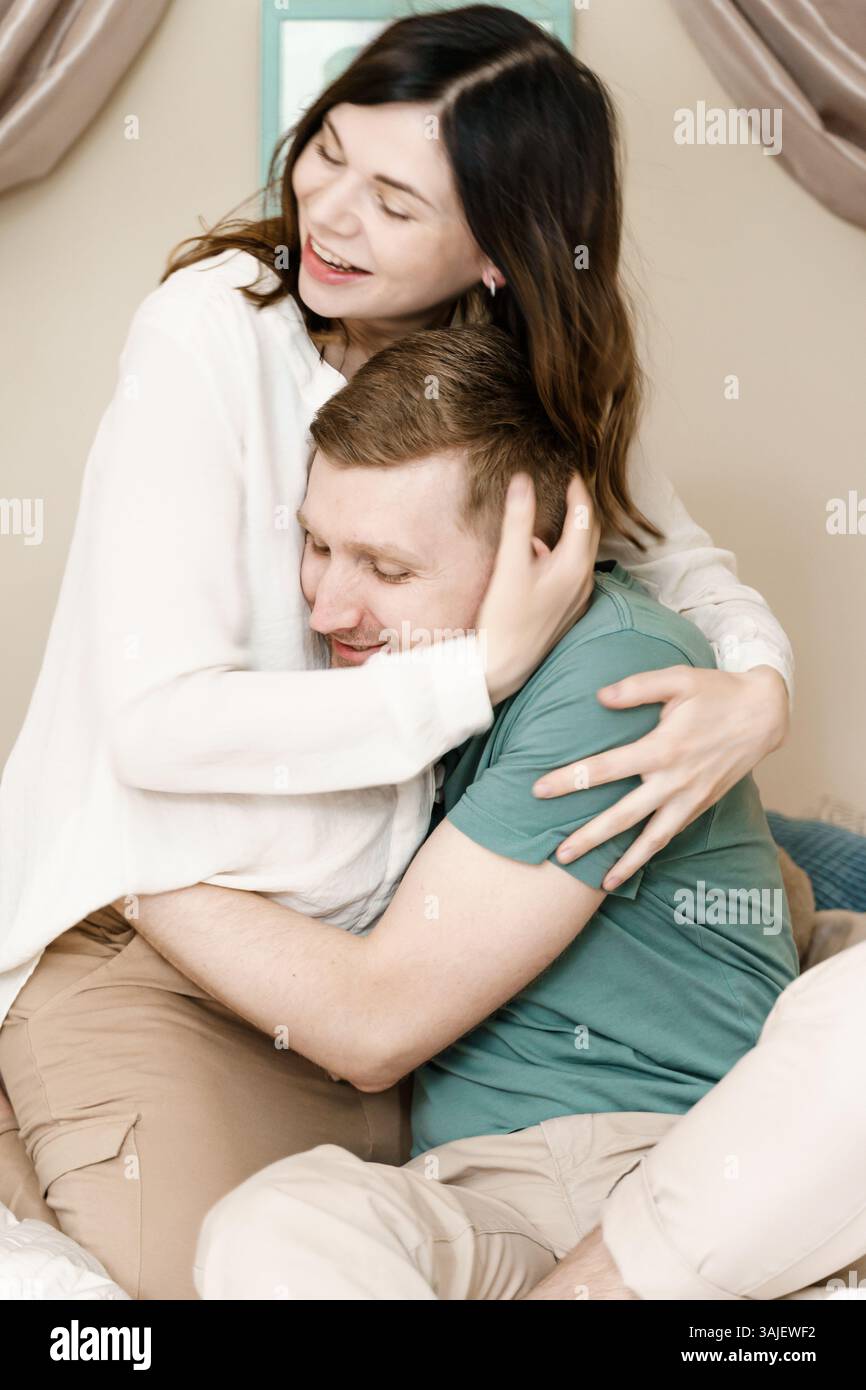 Happy pregnant woman and man hugging and laughing Stock Photo - Alamy