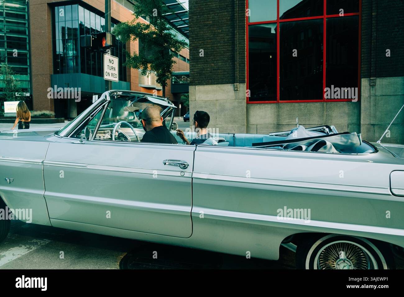 Classic convertible cruising through a city street in summer Stock ...